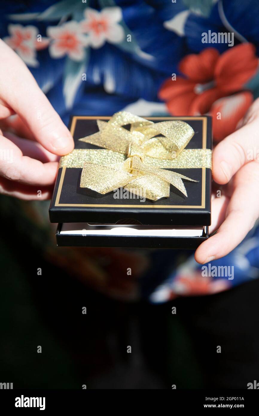 Woman opening a black gift box with a gift card in it Stock Photo - Alamy