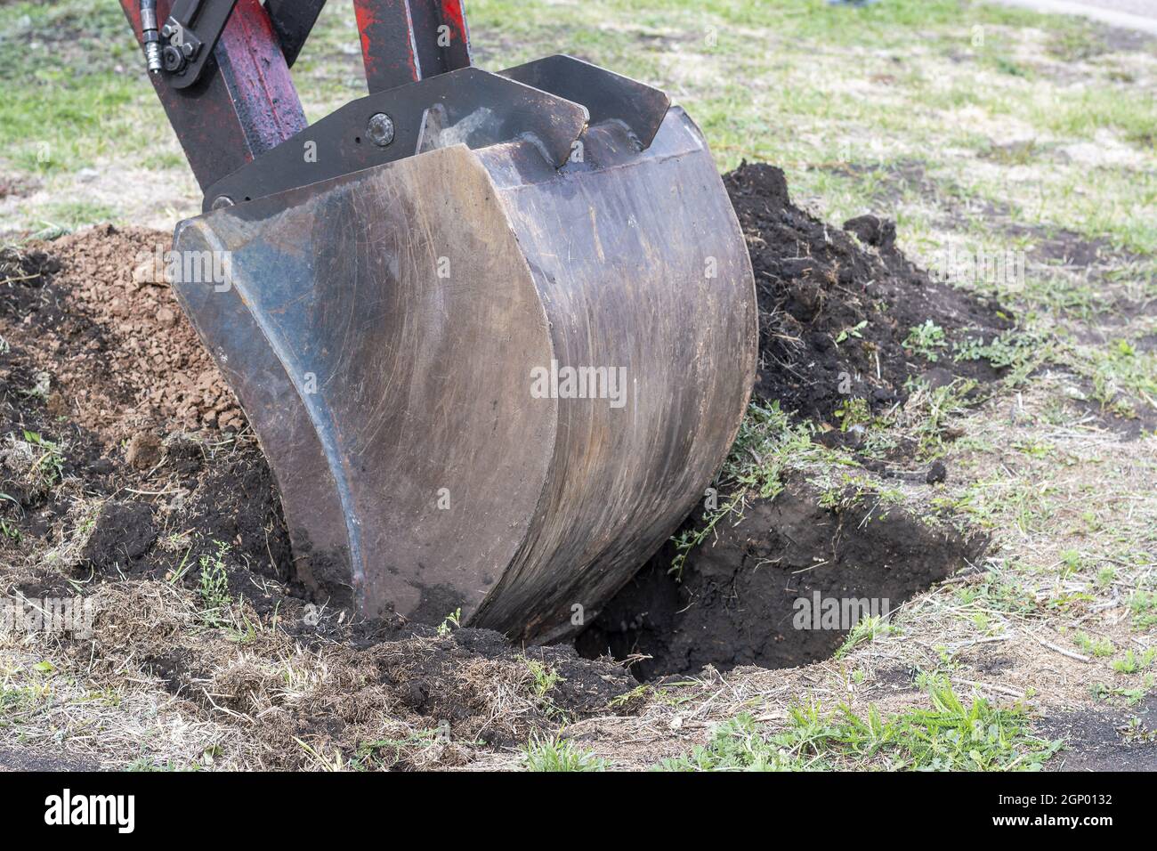 Excavator work. The iron ladle digs into the ground. Digging a hole ...