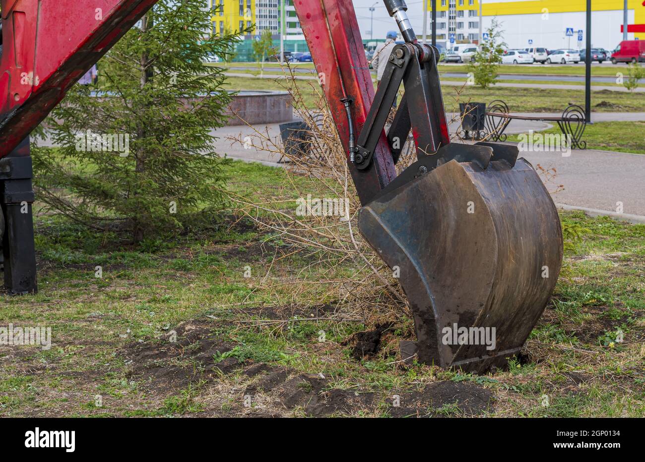 Excavator work. The iron ladle digs into the ground. Digging a hole ...
