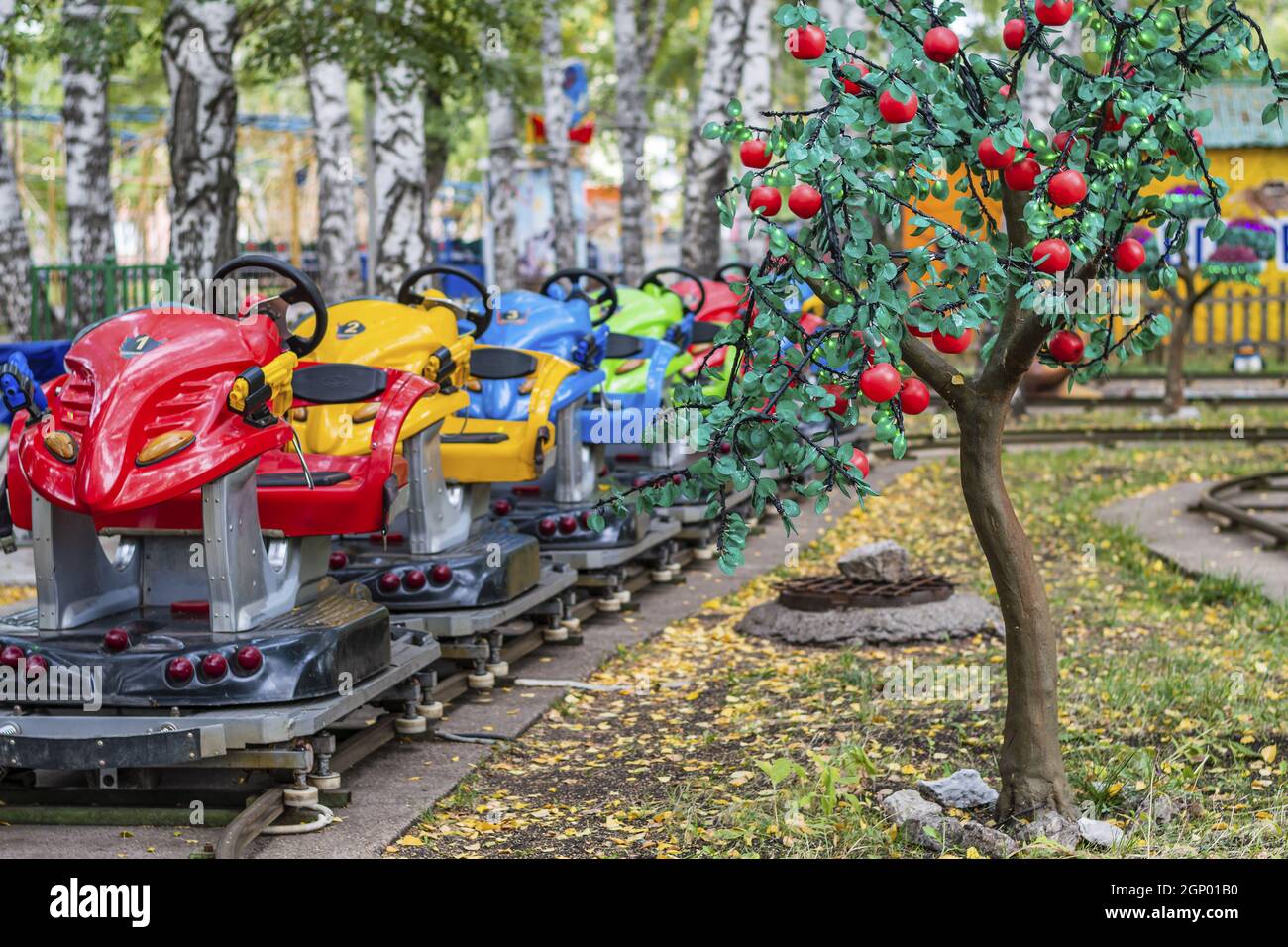 Children's attraction "railway" and artificial tree with ripe apples in ...