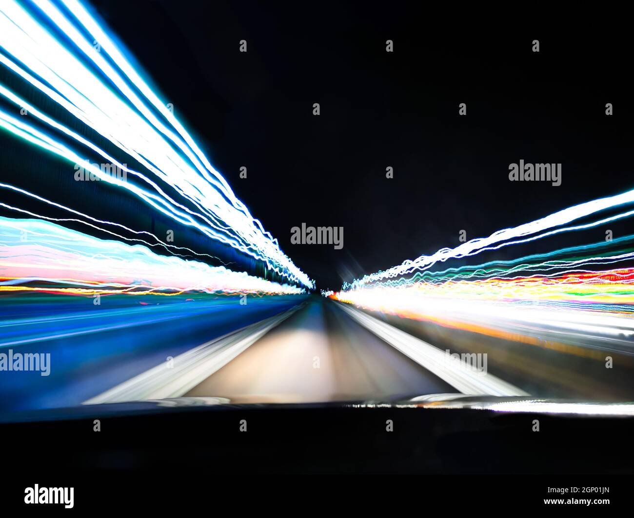 View of night city neon lights on long exposure from car's front window ...