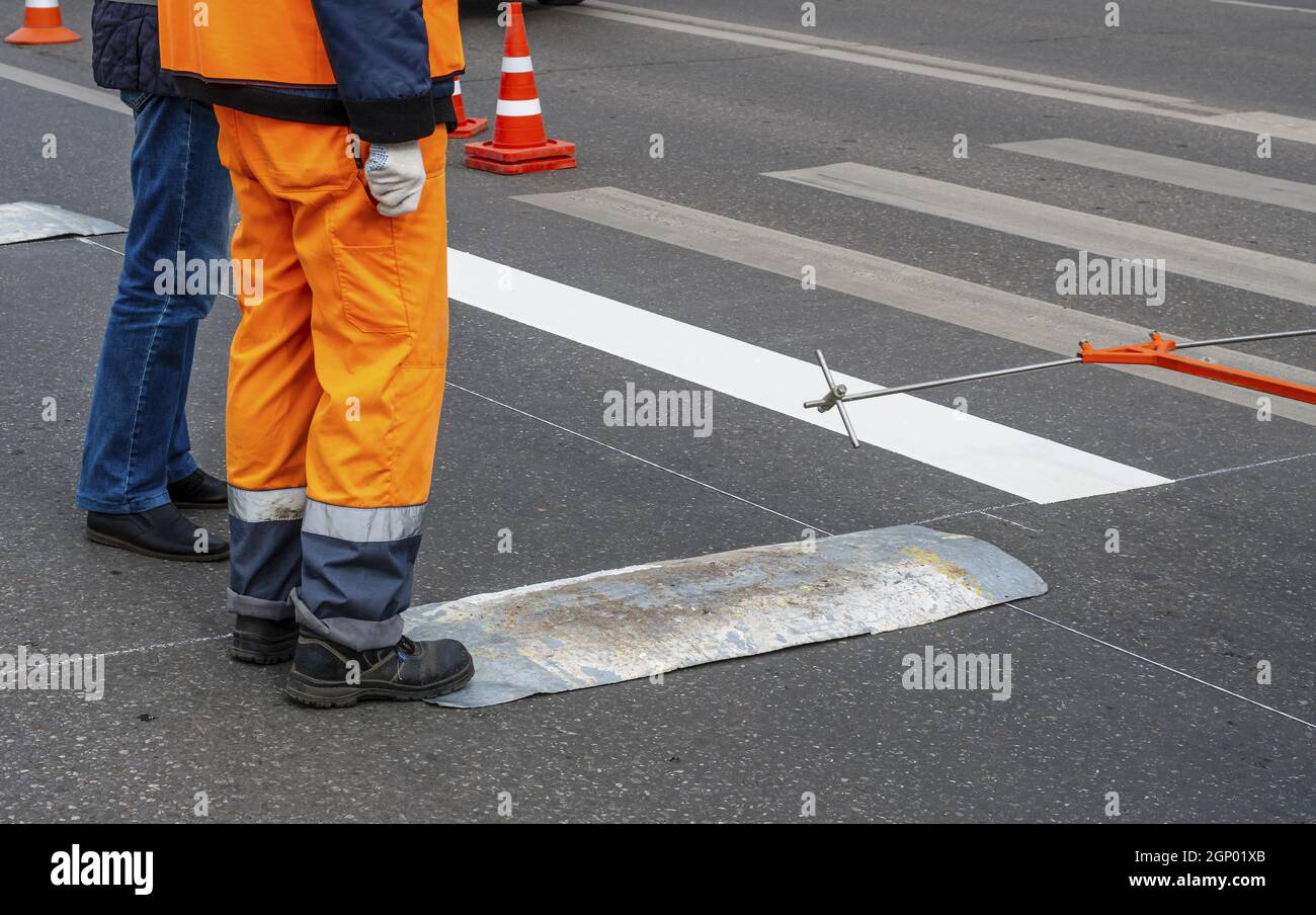 Cut bodies of two workers on side of driveway. Marking of pedestrian ...