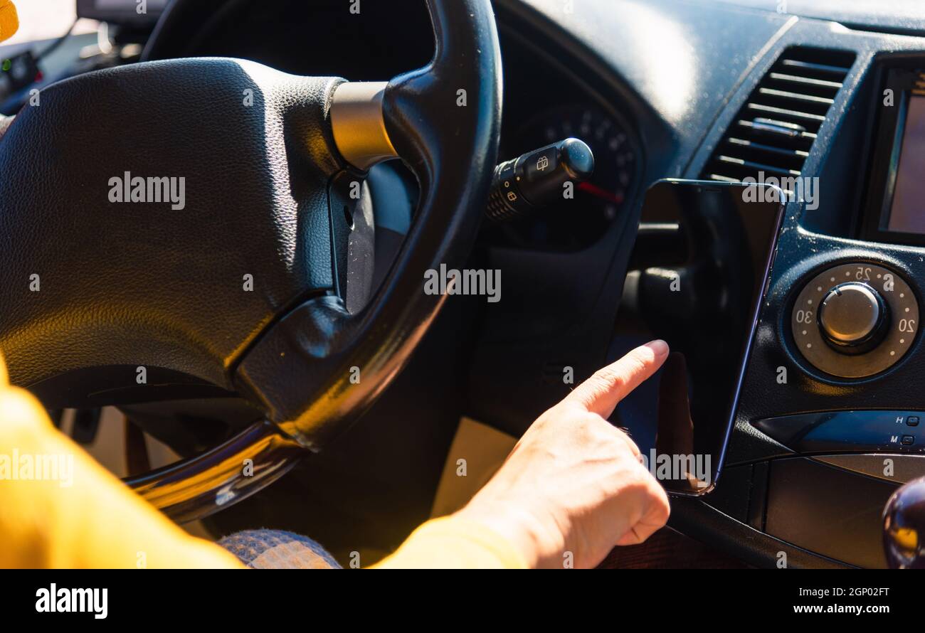 Asian woman inside a car and using touch screen on mobile smartphone ...