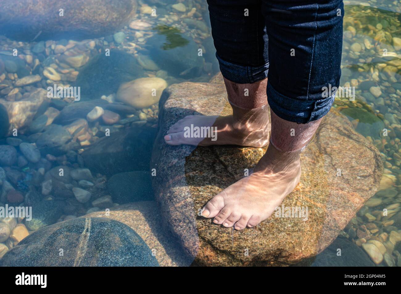 young girl foot on rock in clear transparent river water from top angle ...