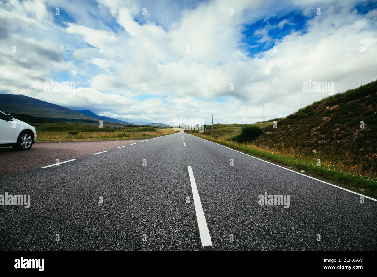 Asphalted, dramatic road in Scotland. Nobody and cloudy sky Stock Photo ...