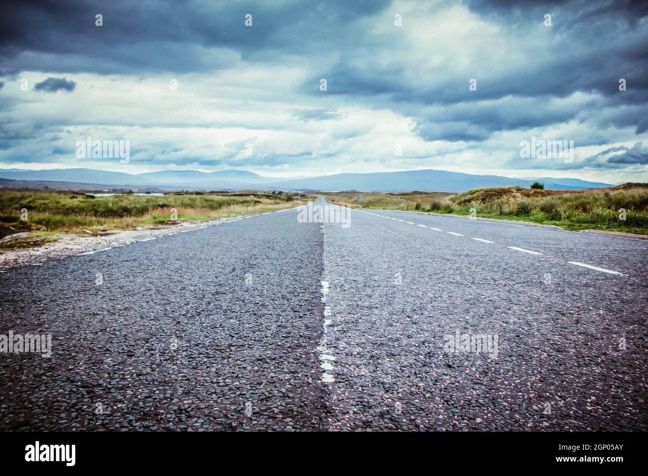 Asphalted, dramatic road in Scotland. Nobody and cloudy sky Stock Photo ...