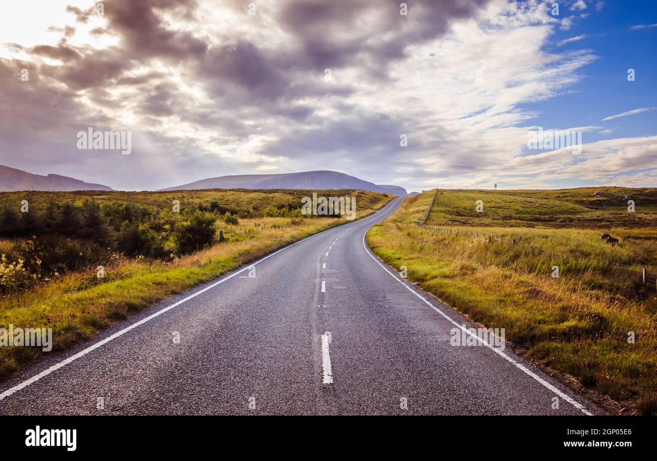 Asphalted, dramatic road in Scotland. Nobody and cloudy sky Stock Photo ...