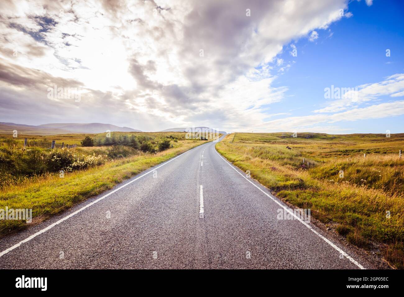 Asphalted, dramatic road in Scotland. Nobody and cloudy sky Stock Photo ...