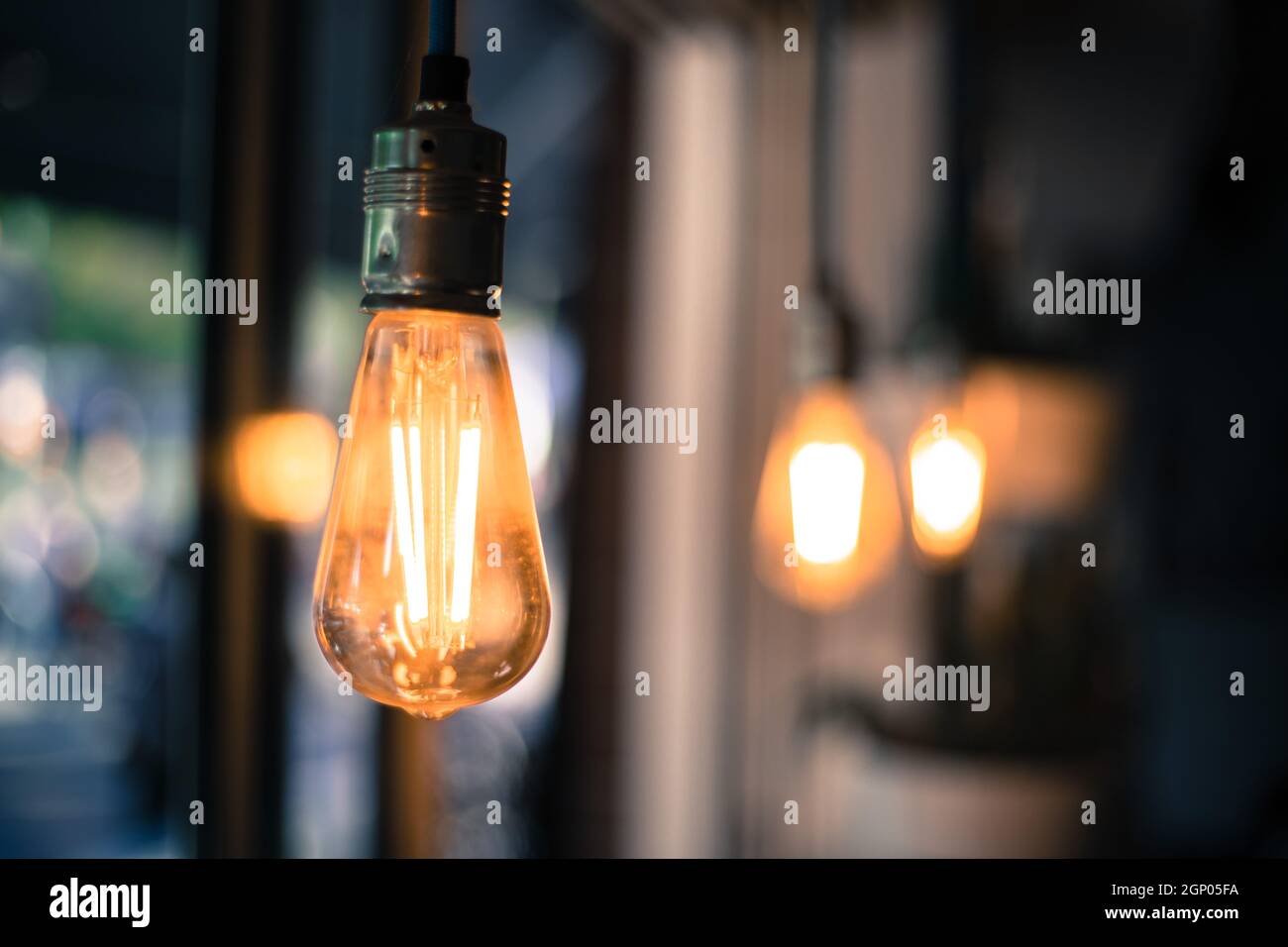 Close up picture of a hanging orange lightbulb in a restaurant or café ...