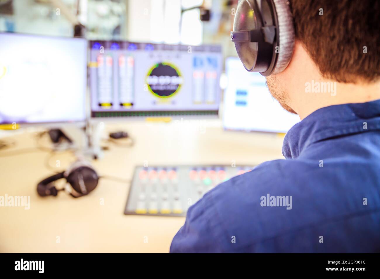 Young man in the broadcasting studio, radio, talking into the ...