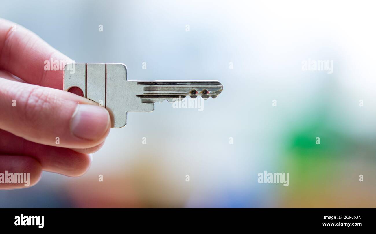 Holding a house key in the hand: New home and property Stock Photo - Alamy