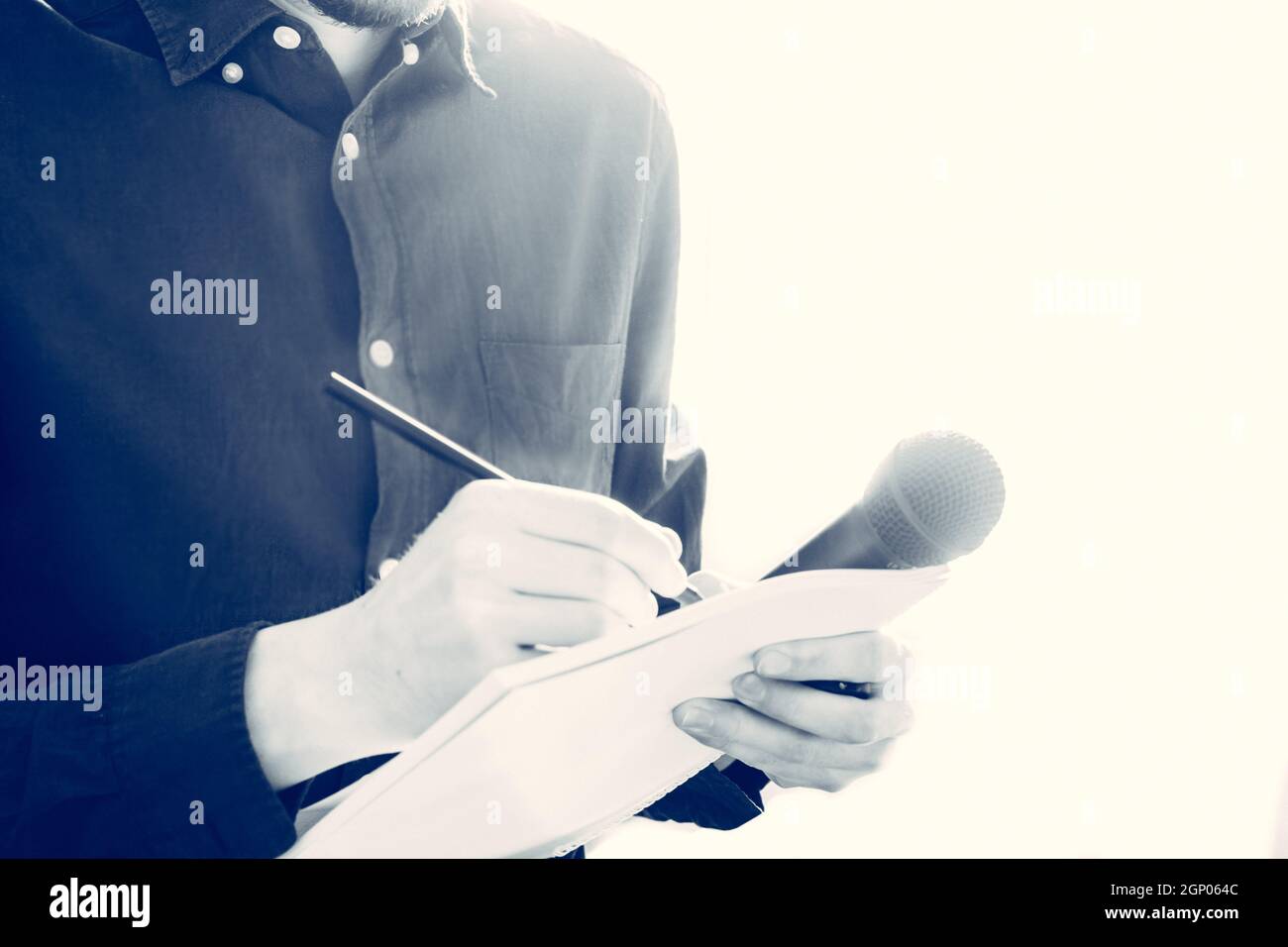 Cut-out of a male journalist in a blue shirt at a news conference who ...