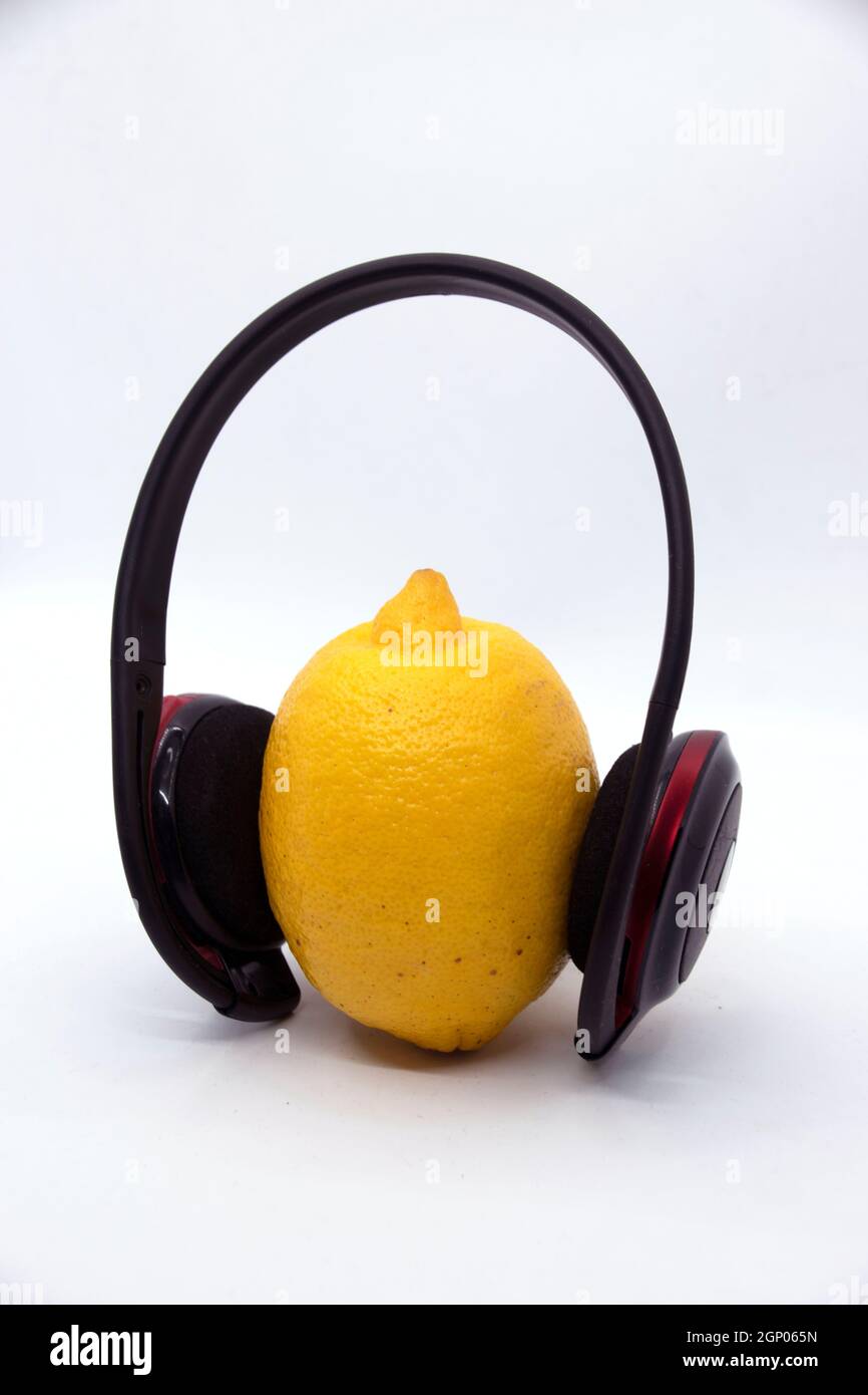 Yellow lemon in headphones on a white background Stock Photo - Alamy