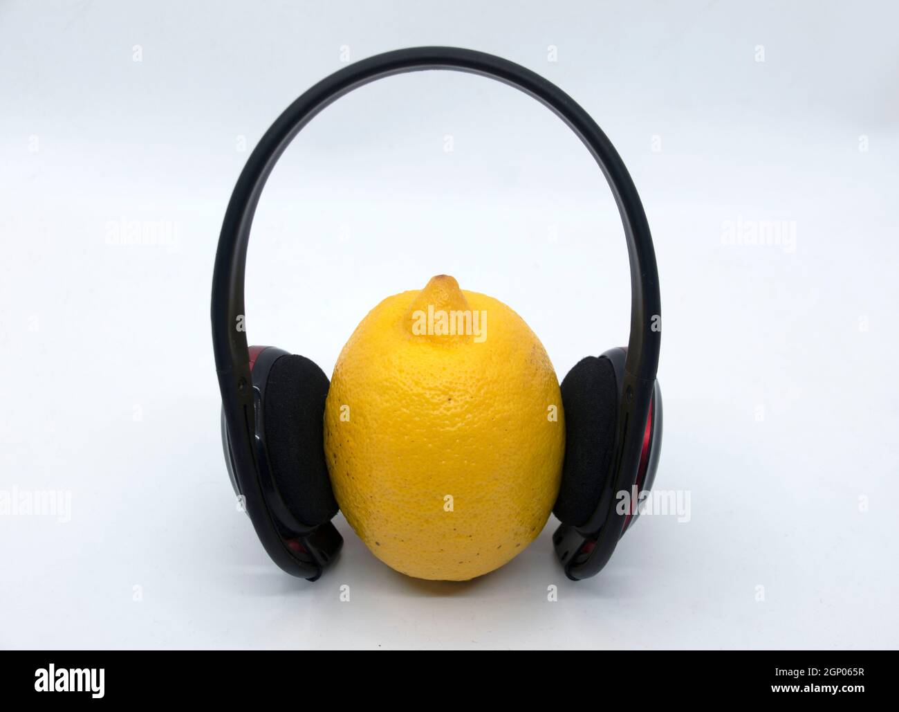 Yellow lemon in headphones on a white background Stock Photo - Alamy