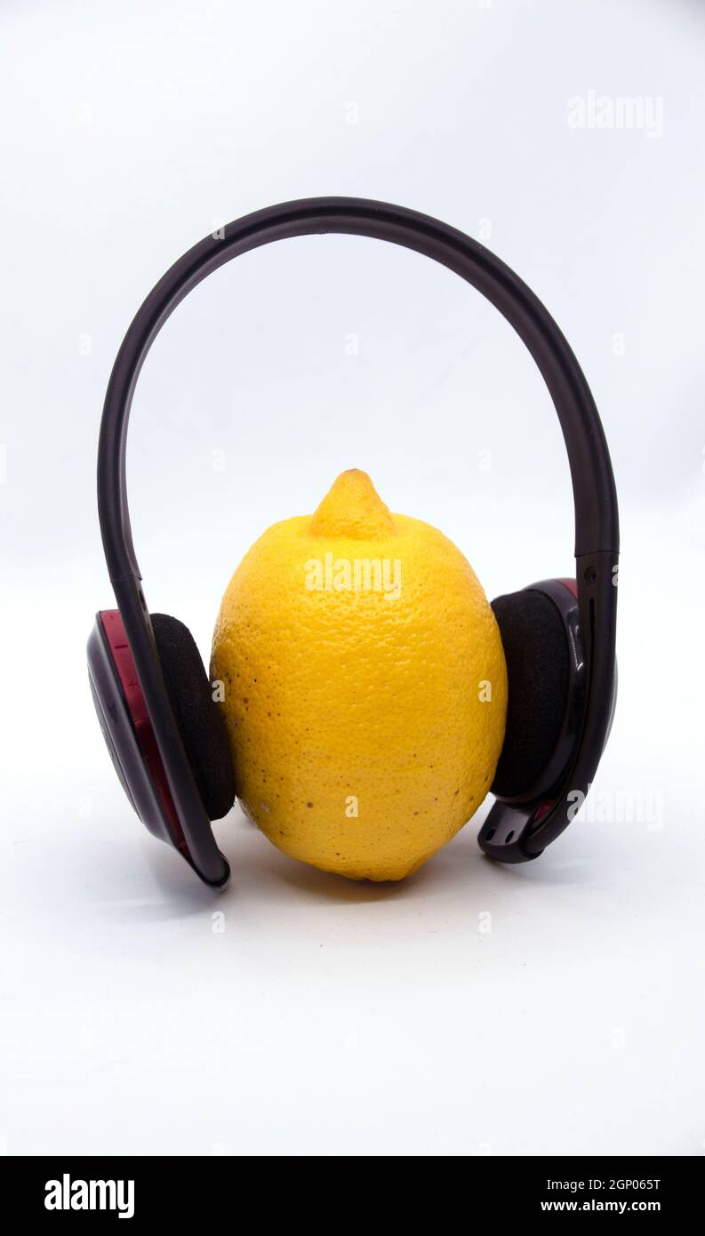 Yellow lemon in headphones on a white background Stock Photo - Alamy