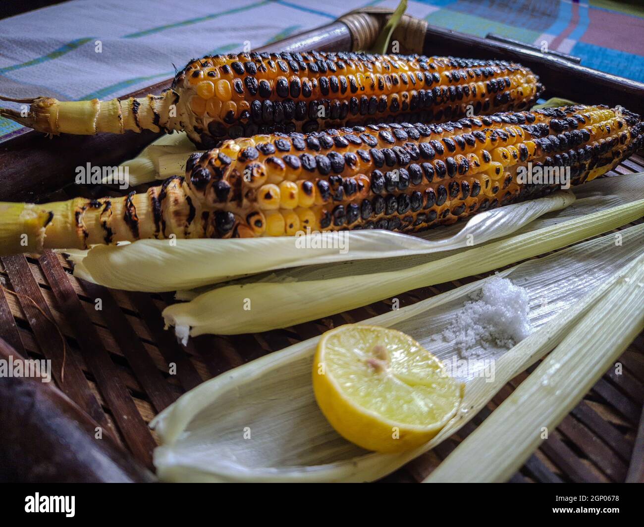 spicy sweet corn burn in fire with lemon and salt in a wood tray from ...