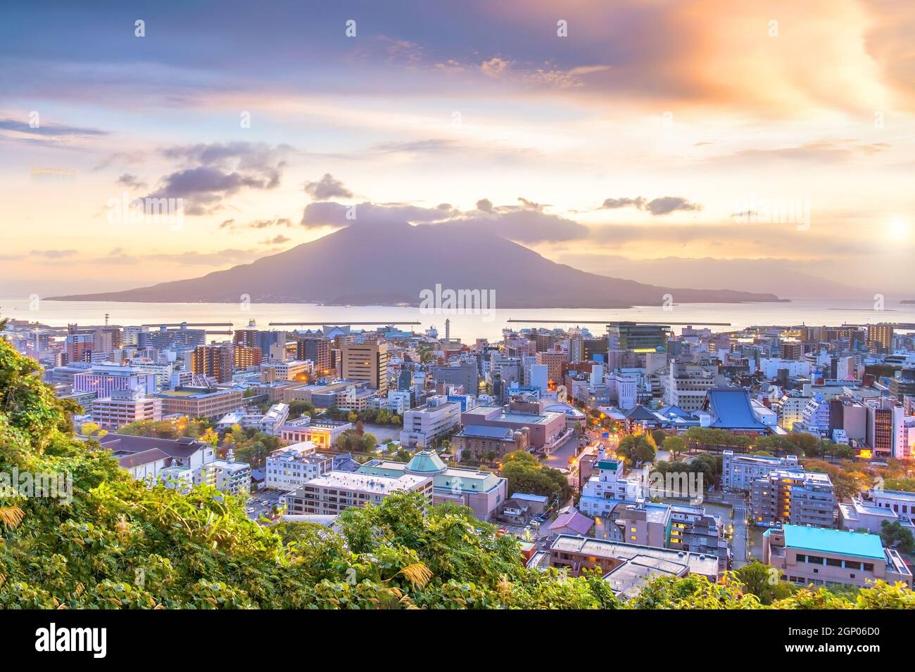 Kagoshima city downtown skyline cityscape with Sakurajima Volcano in Kyushu, Japan at sunset ...