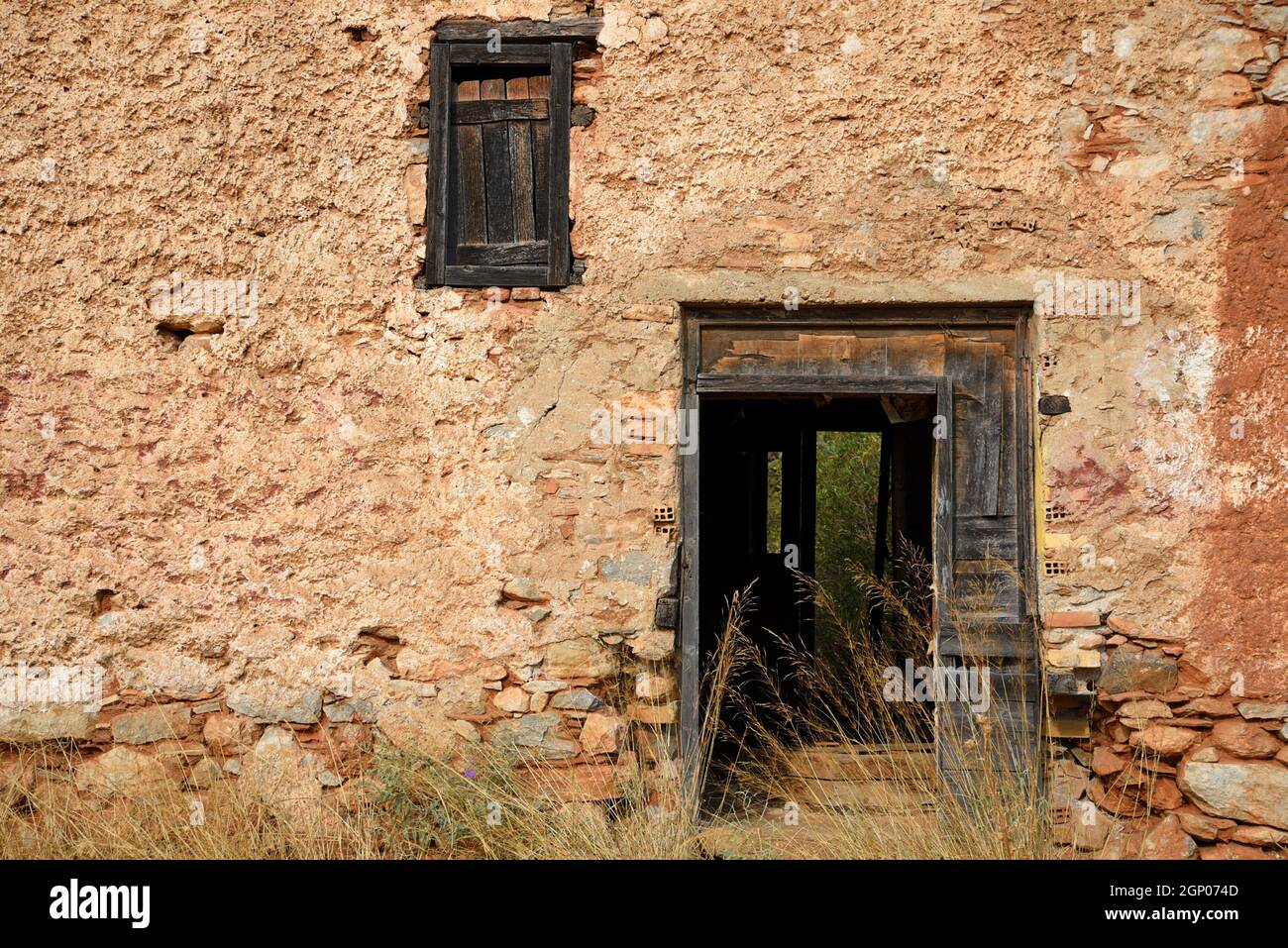 Old abandoned rural house facade with a mortared claystone wall and ...