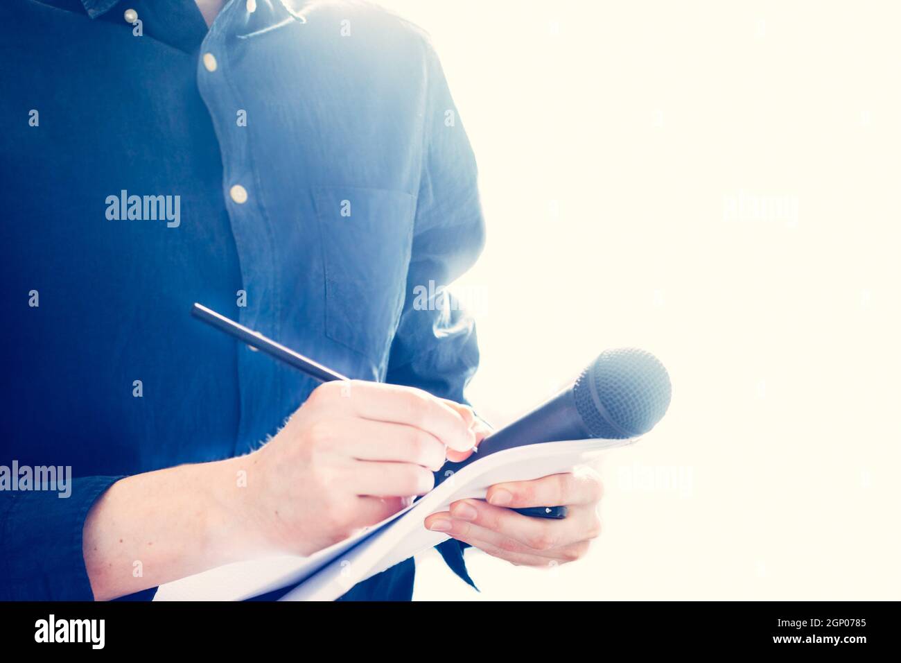 Cut-out of a male journalist in a blue shirt at a news conference who ...