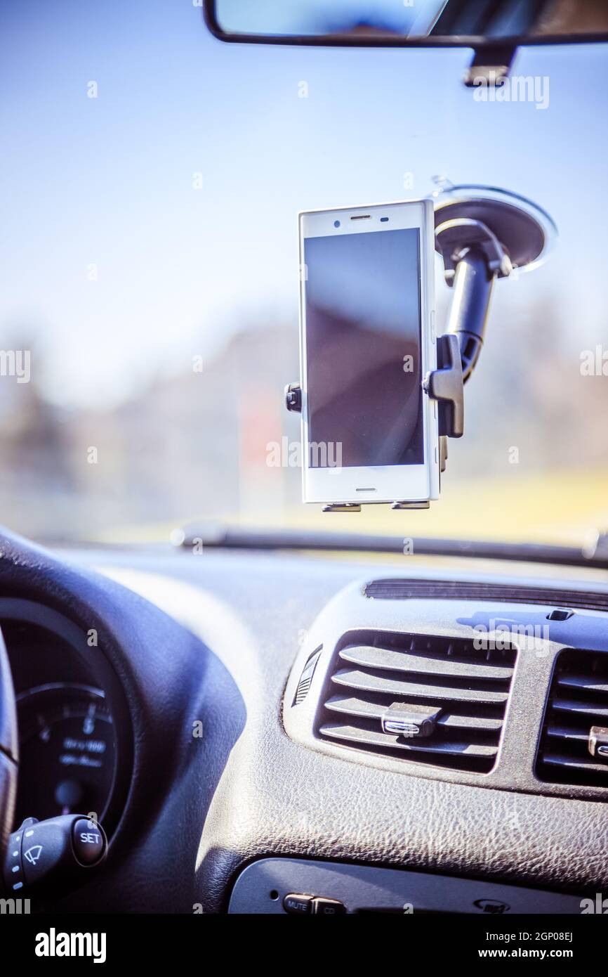 Interior of a modern car on a sunny day. Smartphone on mobile mount ...
