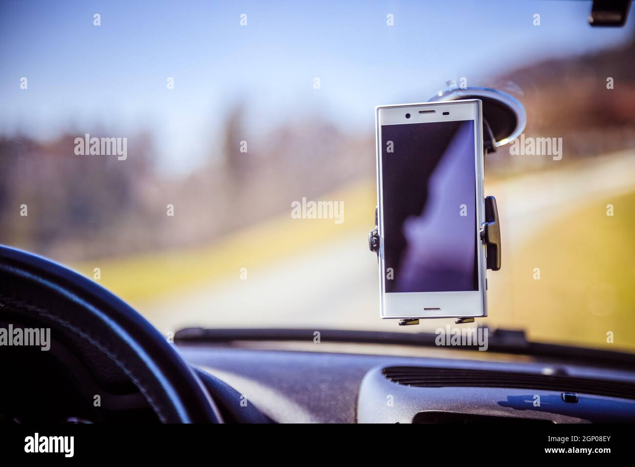 Interior of a modern car on a sunny day. Smartphone on mobile mount ...