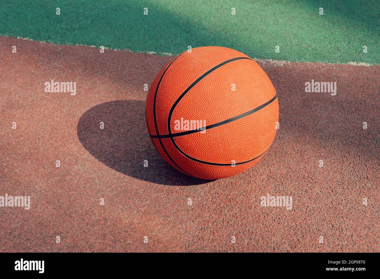 Side view of orange ball for basketball lying on the rubber sport court ...