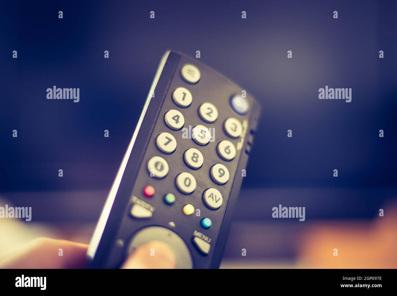 TV remote control in the foreground, tv in the blurry background Stock ...