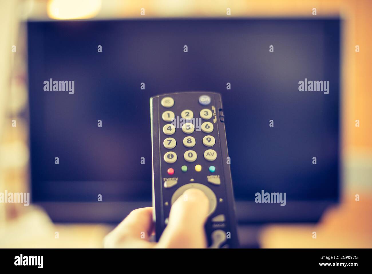 TV remote control in the foreground, tv in the blurry background Stock ...