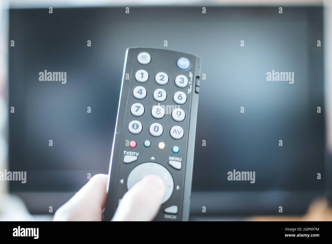 TV remote control in the foreground, tv in the blurry background Stock ...