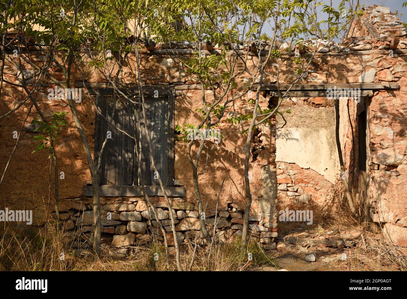 Old abandoned rural house facade with an aged mortared claystone wall ...