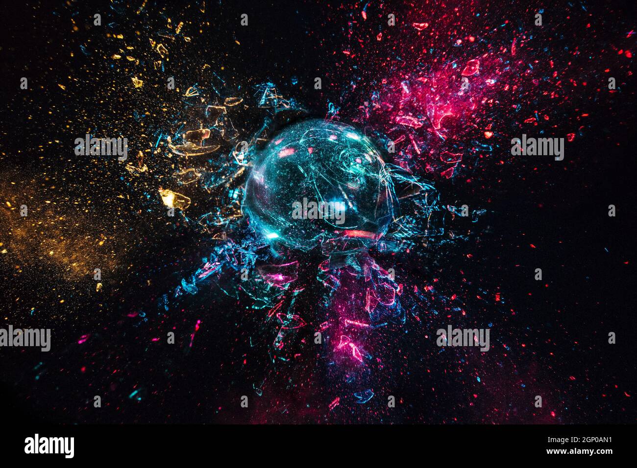 explosion of a glass ball with colored lights, black background. high ...
