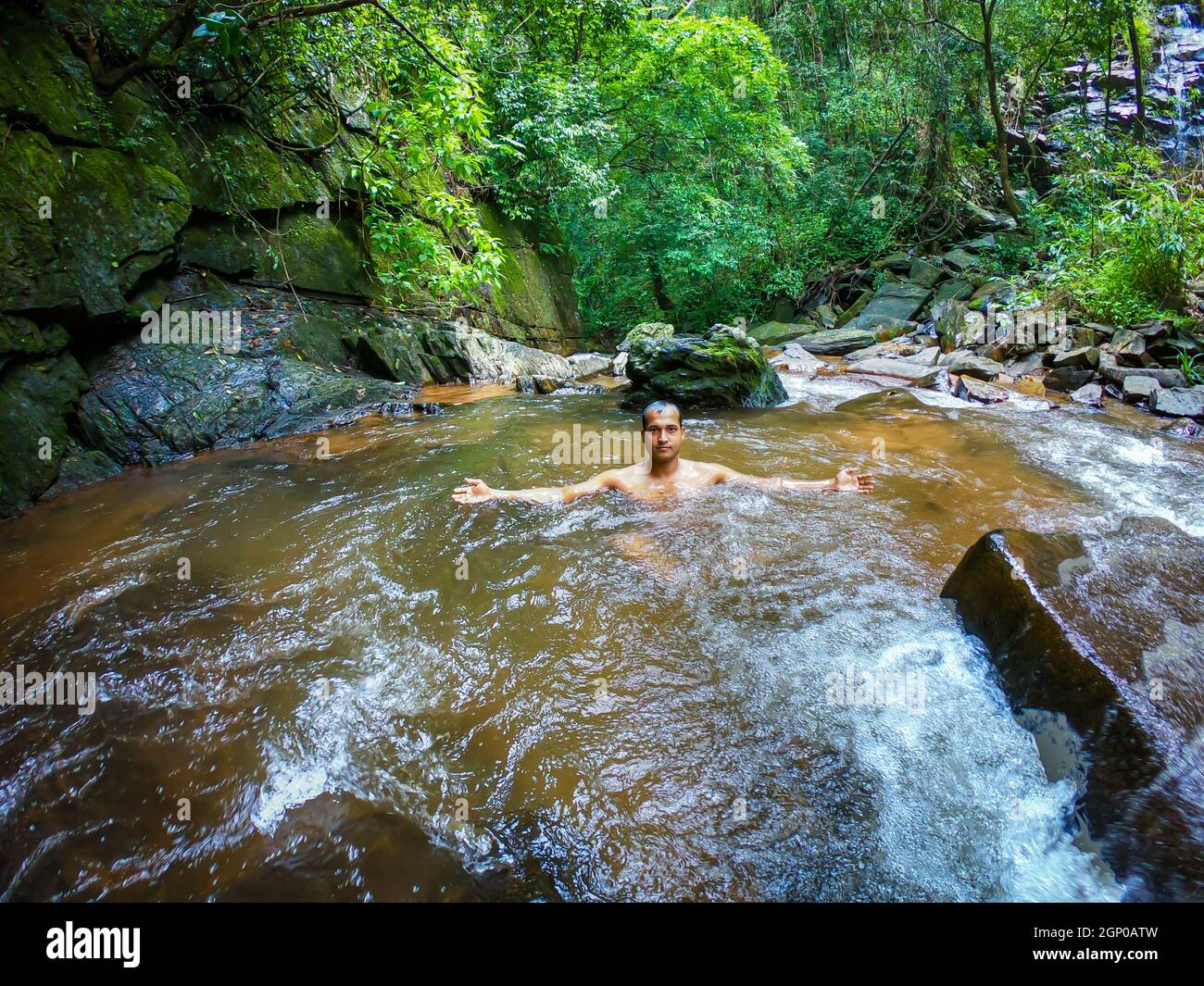 man bathing in natural waterfall in forests at morning from different ...