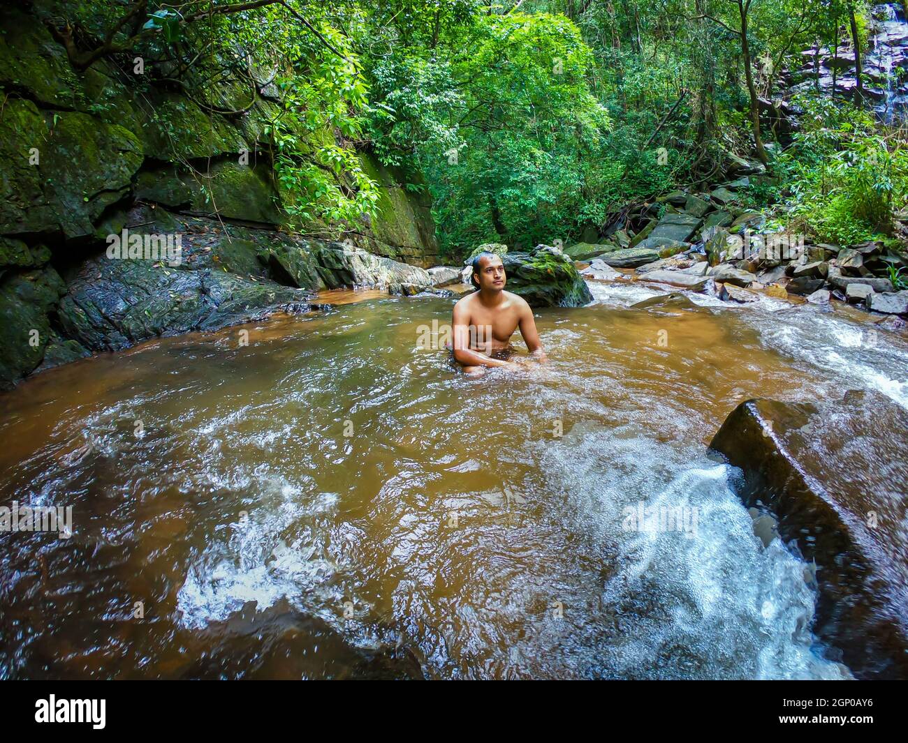 man bathing in natural waterfall in forests at morning from different ...