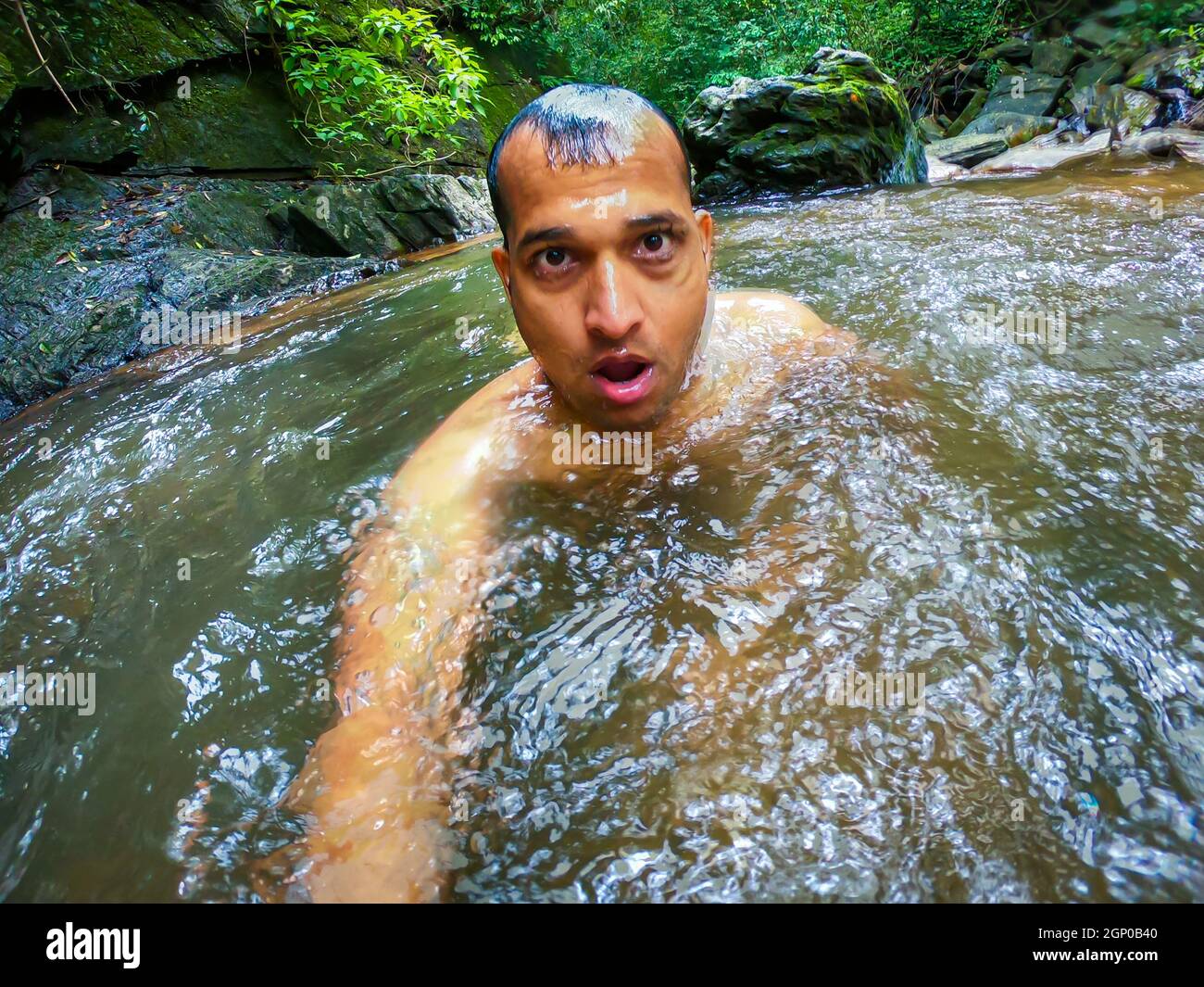 man bathing in natural waterfall in forests at morning from different ...