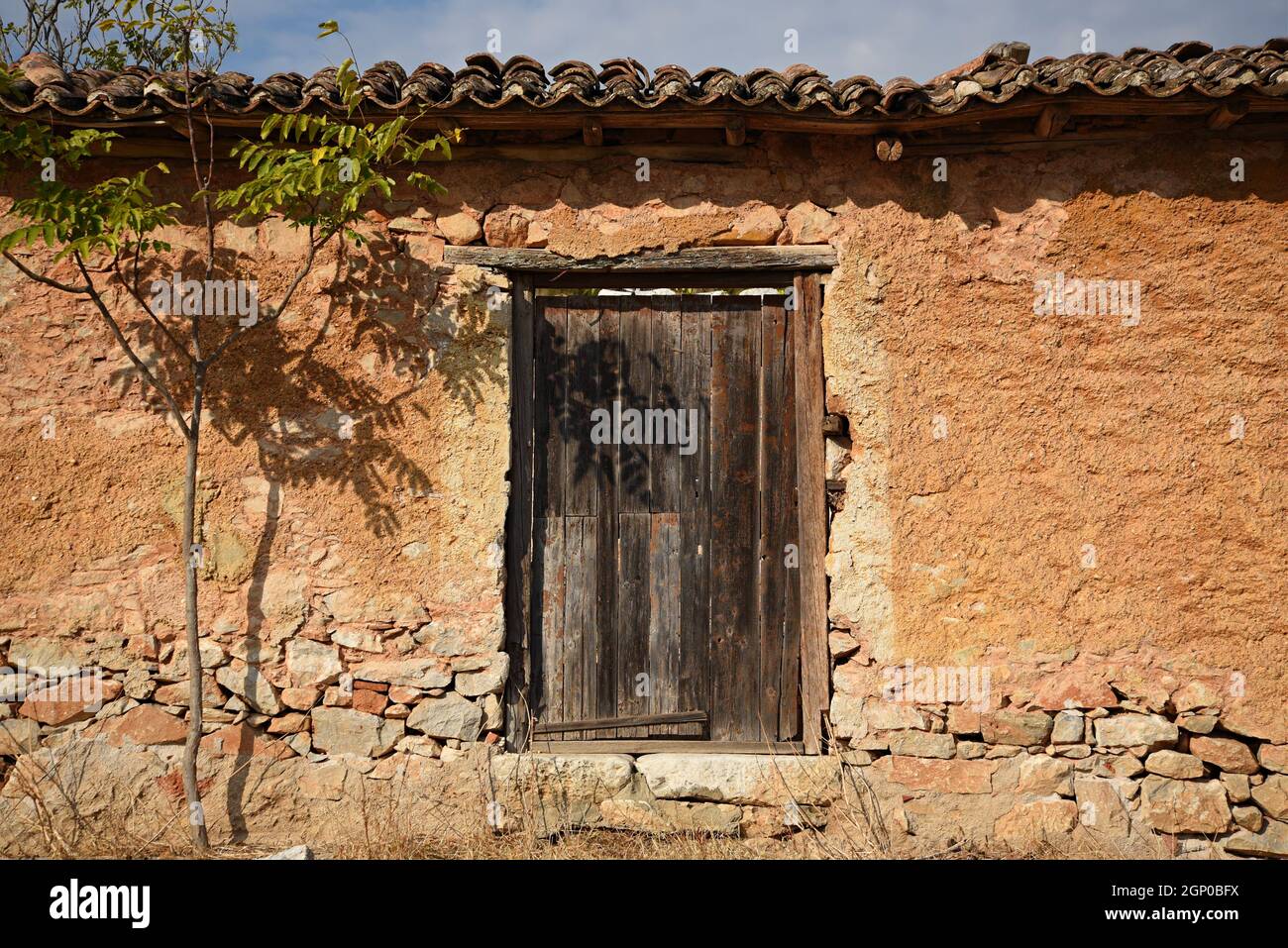 Old abandoned rural house weathered facade with aged claystone walls, a ...