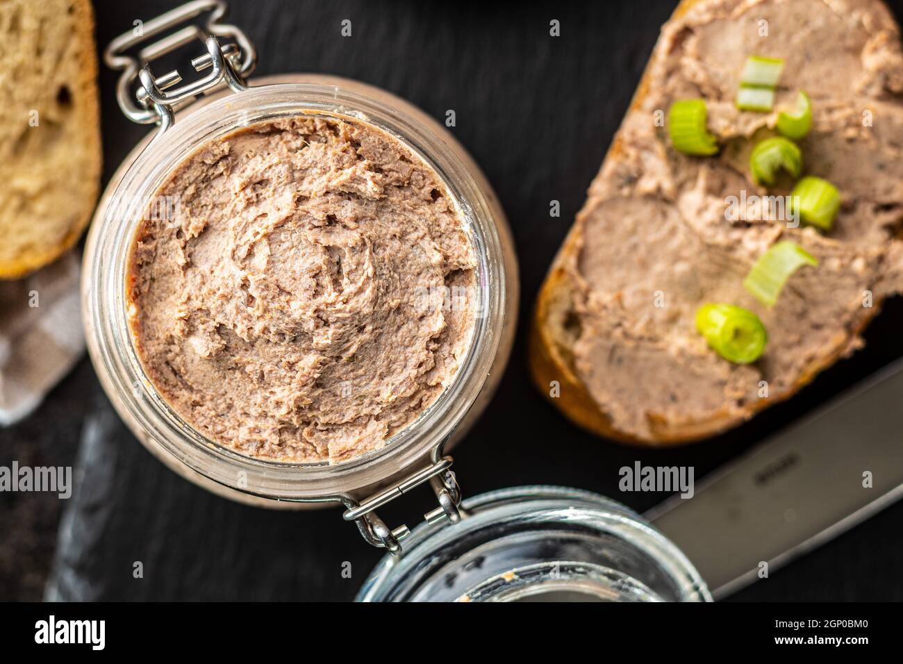 Liver pate in jar on black table. Top view Stock Photo - Alamy