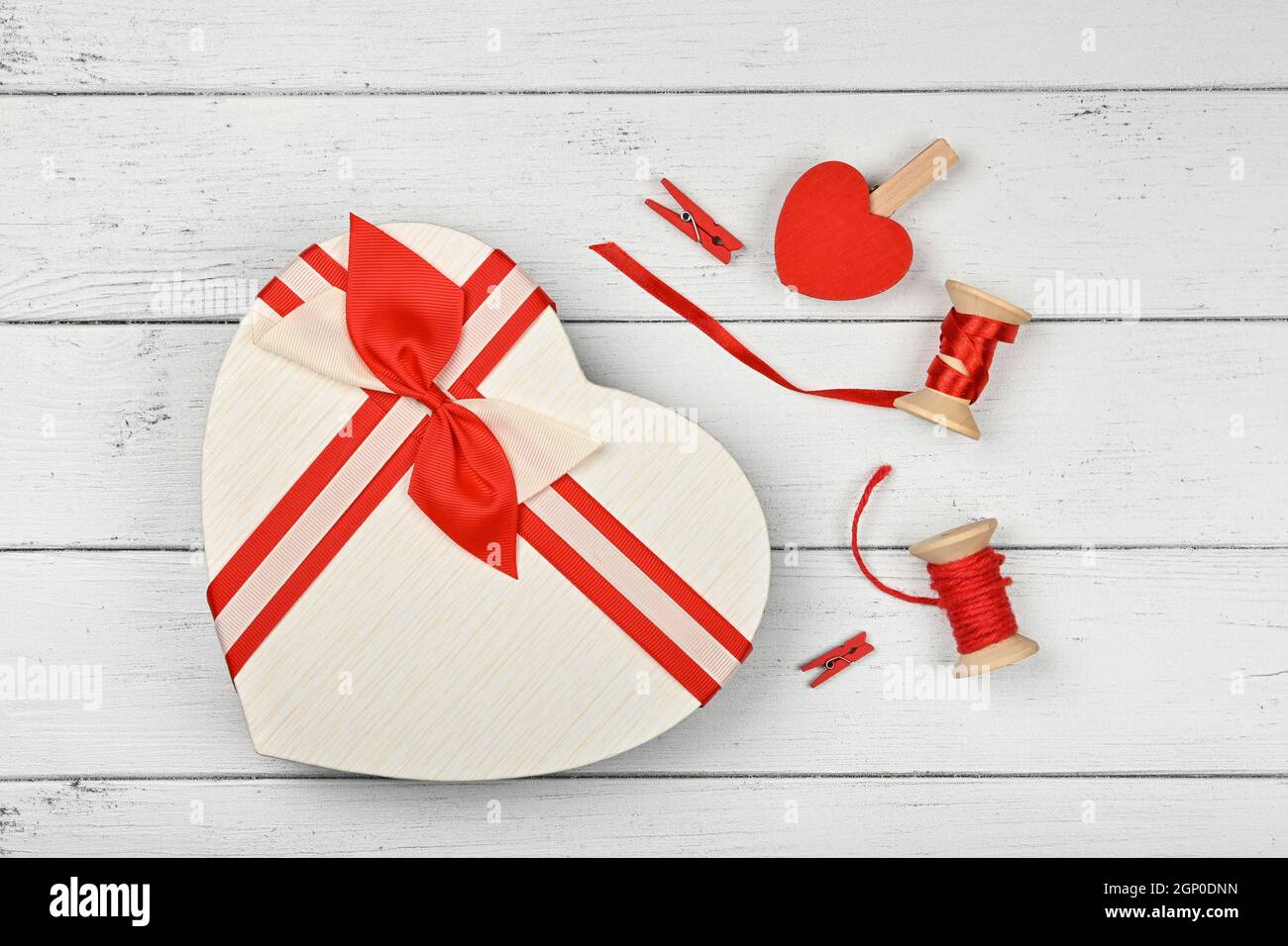 Packing Valentine heart shaped gift box with ribbon chiffon bow over ...