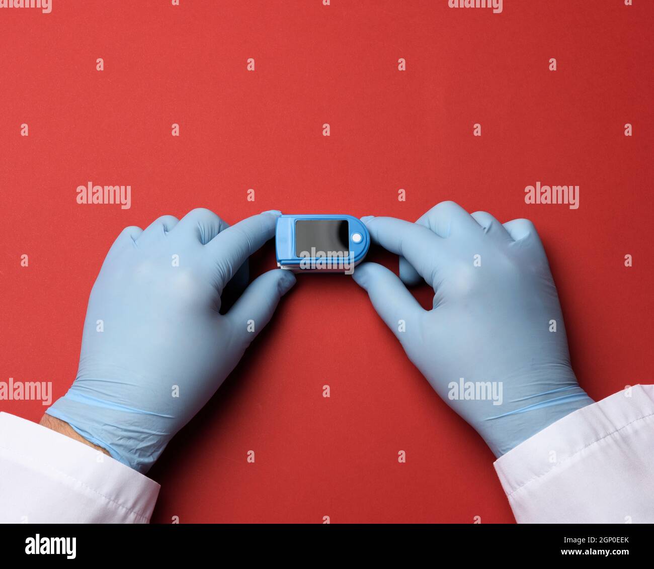 electronic pulse oximeter in the hands of a doctor, wearing blue latex ...