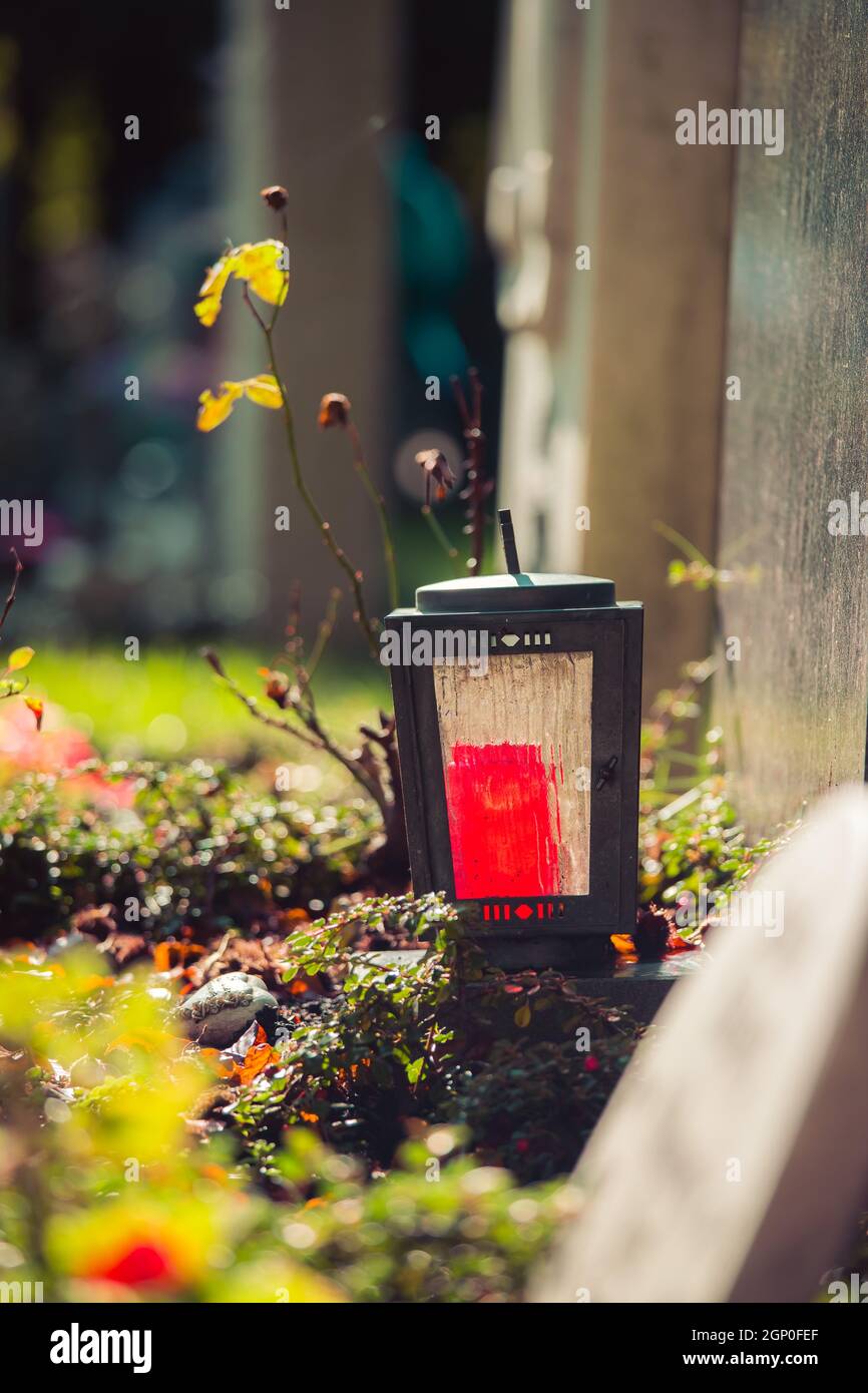 Candle in an iron lantern on a grave at a cemetery Stock Photo - Alamy