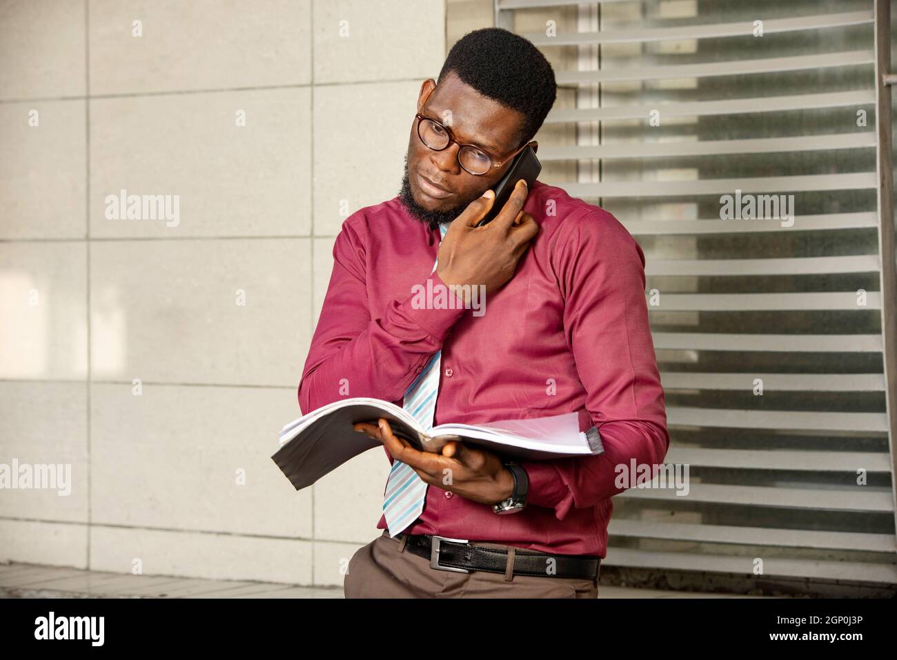 young business man standing using his cell phone while calling outside ...