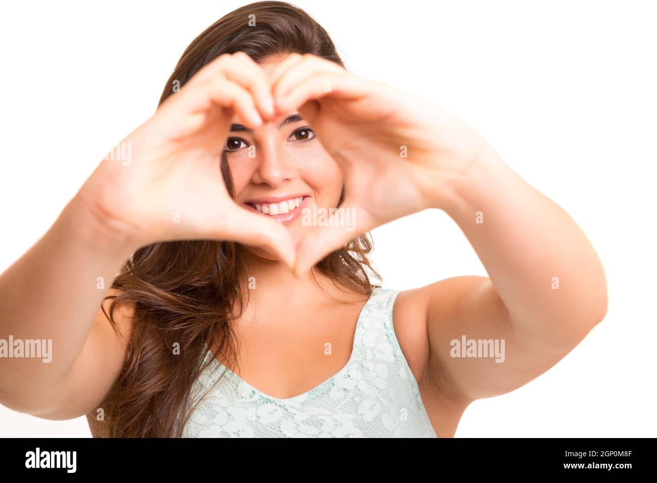 Beautiful woman making a heart shape with her hands, isolated over ...