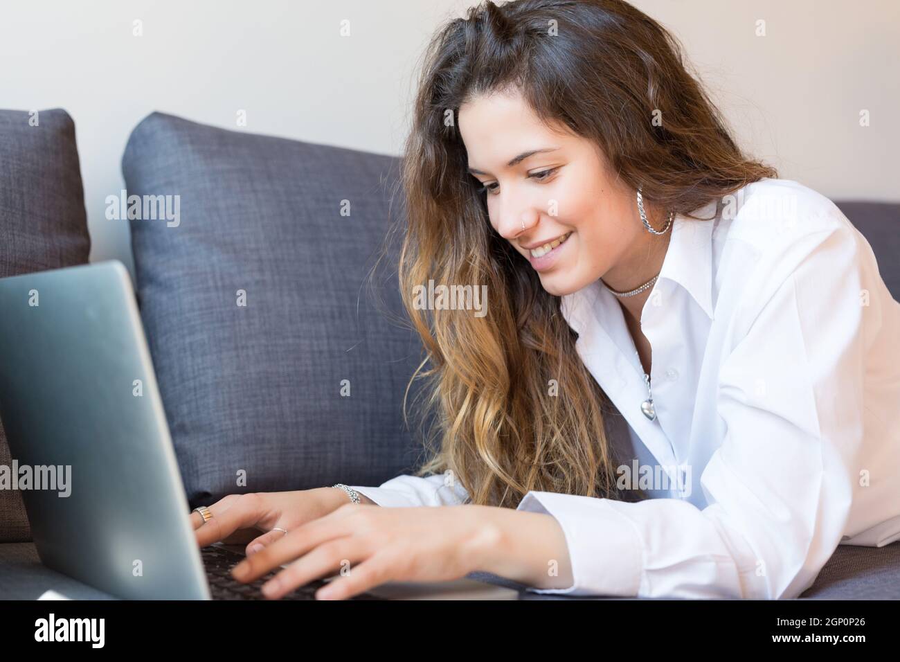 Beautiful woman relaxing with a computer Stock Photo - Alamy