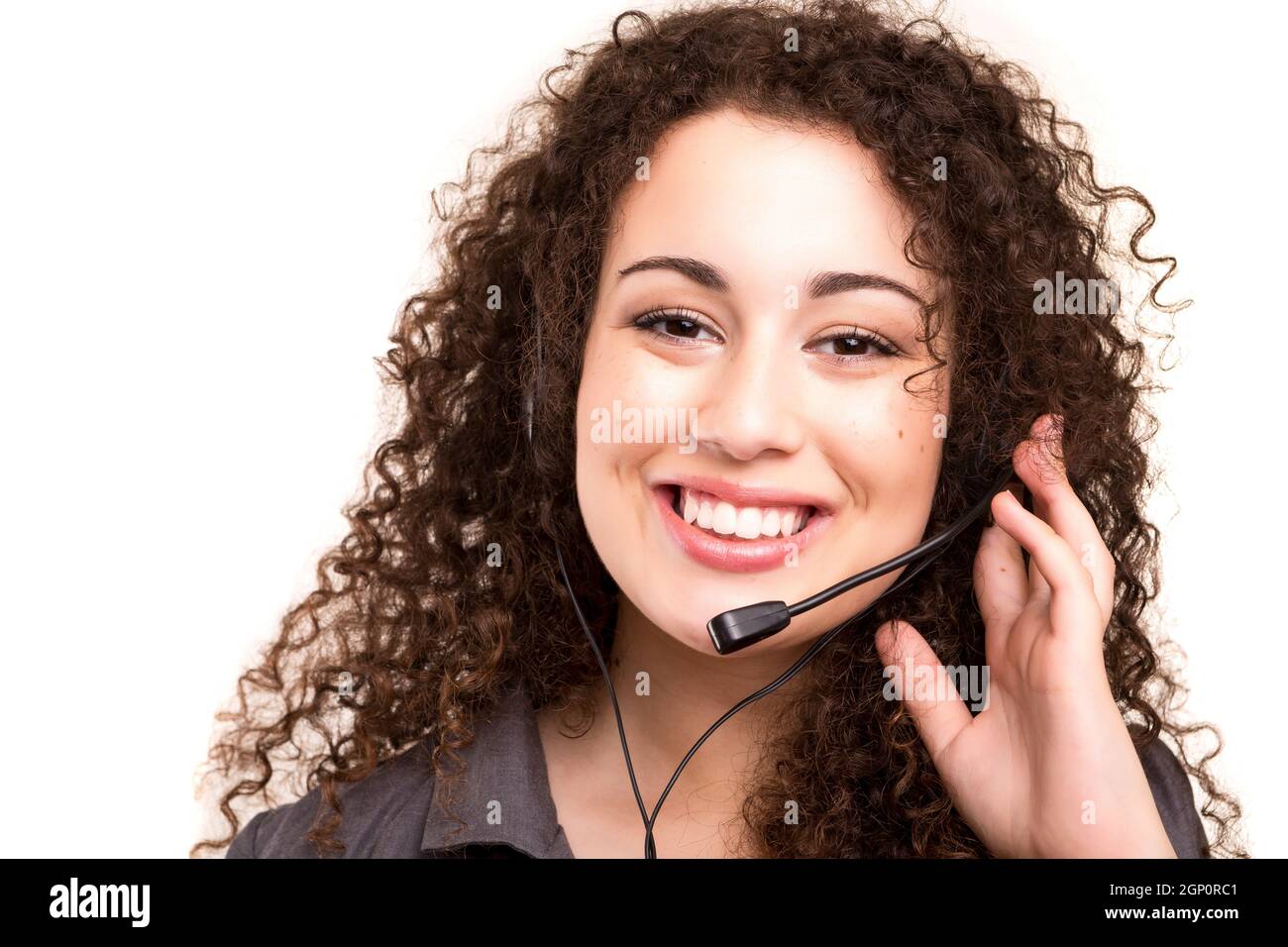 A friendly asian telephone operator smiling isolated over a white ...