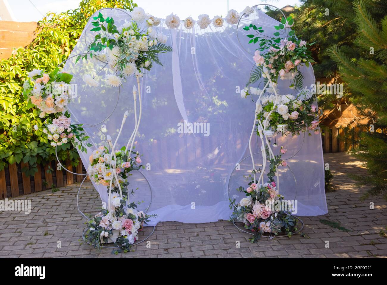 Wedding arch decorated with cloth and flowers outdoors. Beautiful ...