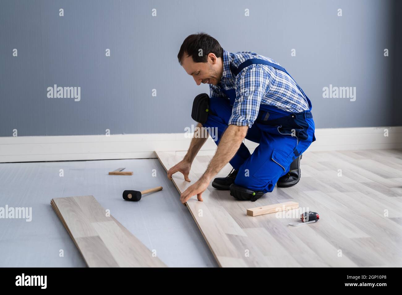 Hardwood Floor Renovation. Construction Worker Doing New Laminate ...