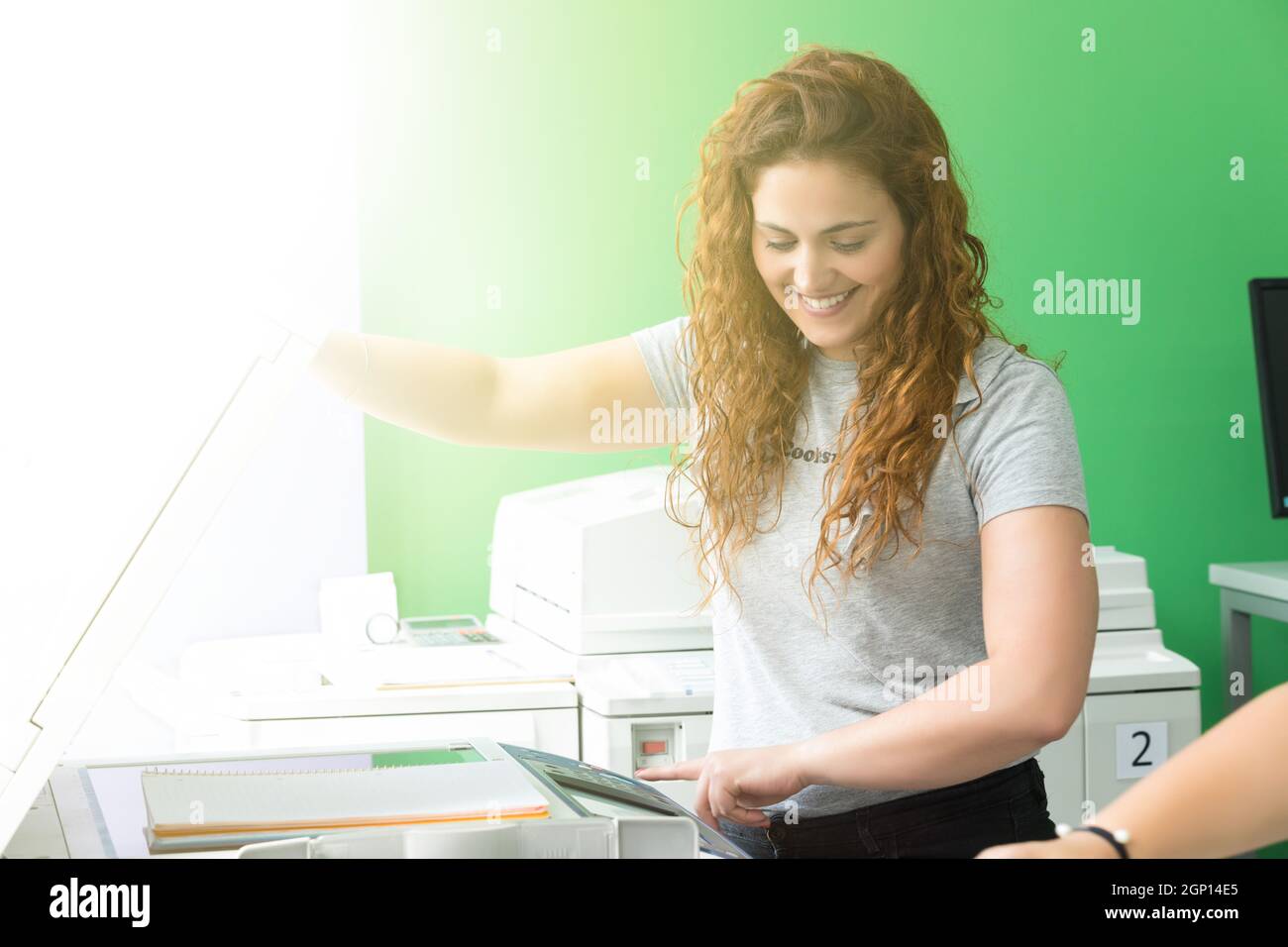 A young student at a copy center taking some copies for her final exams ...