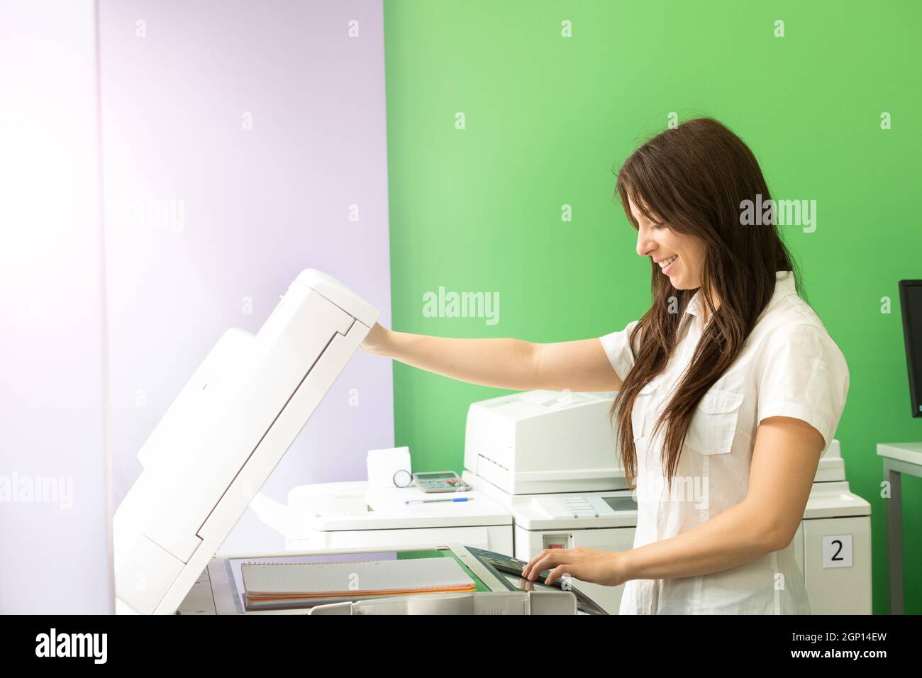 A young student at a copy center taking some copies for her final exams ...