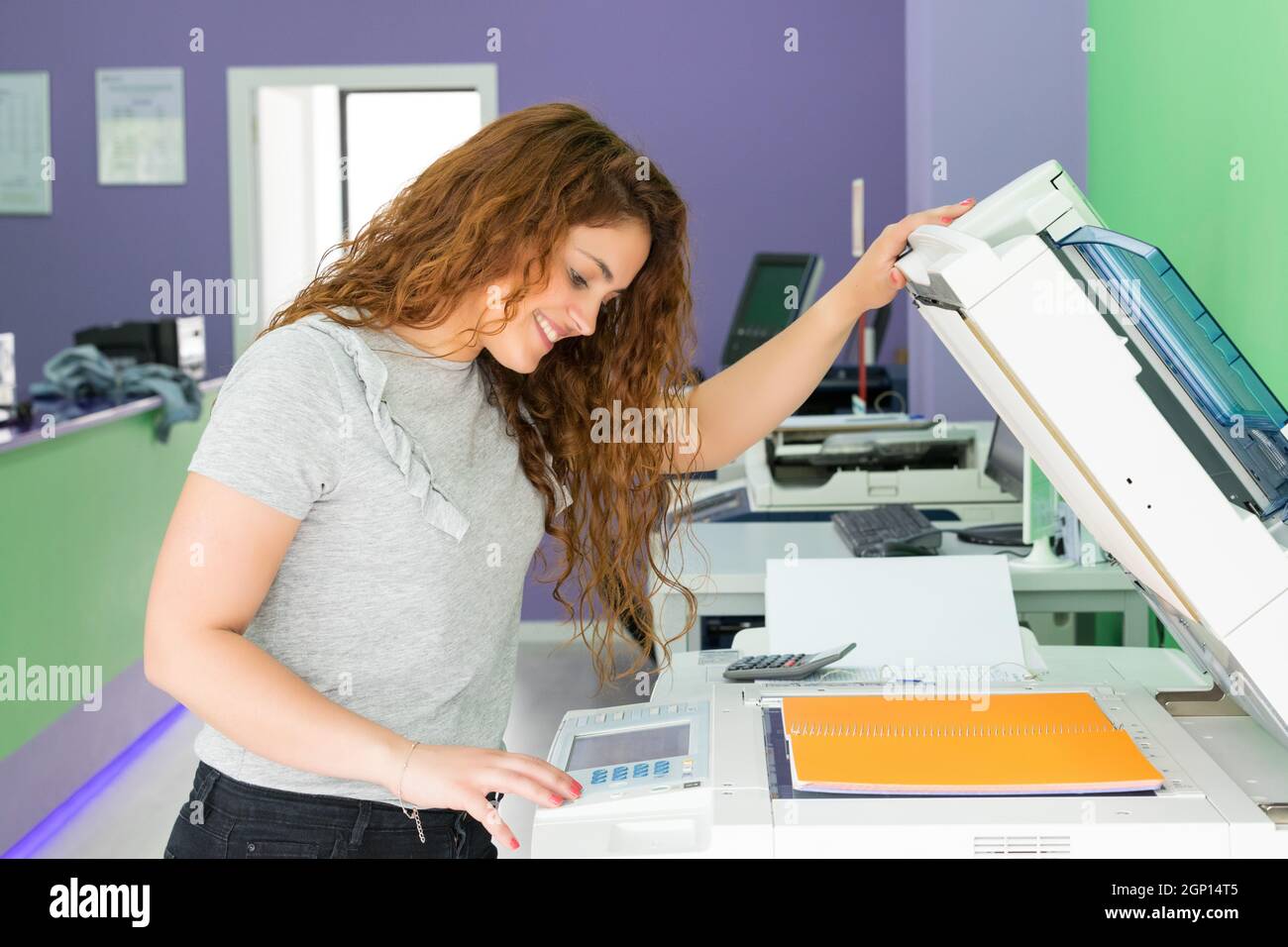 A young student at a copy center taking some copies for her final exams ...