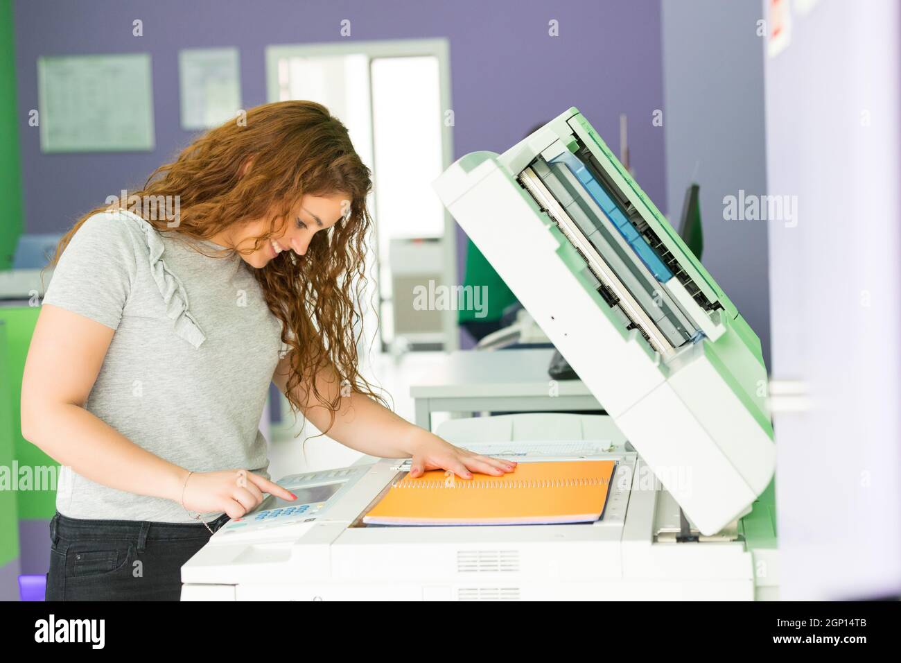 A young student at a copy center taking some copies for her final exams ...