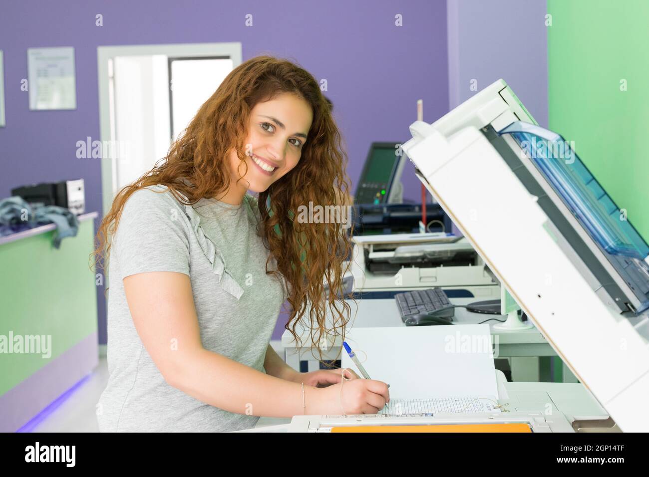 A young student at a copy center taking some copies for her final exams ...